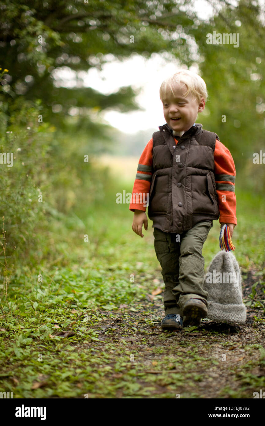 Young boy standing outside holding his winter hat Stock Photo - Alamy