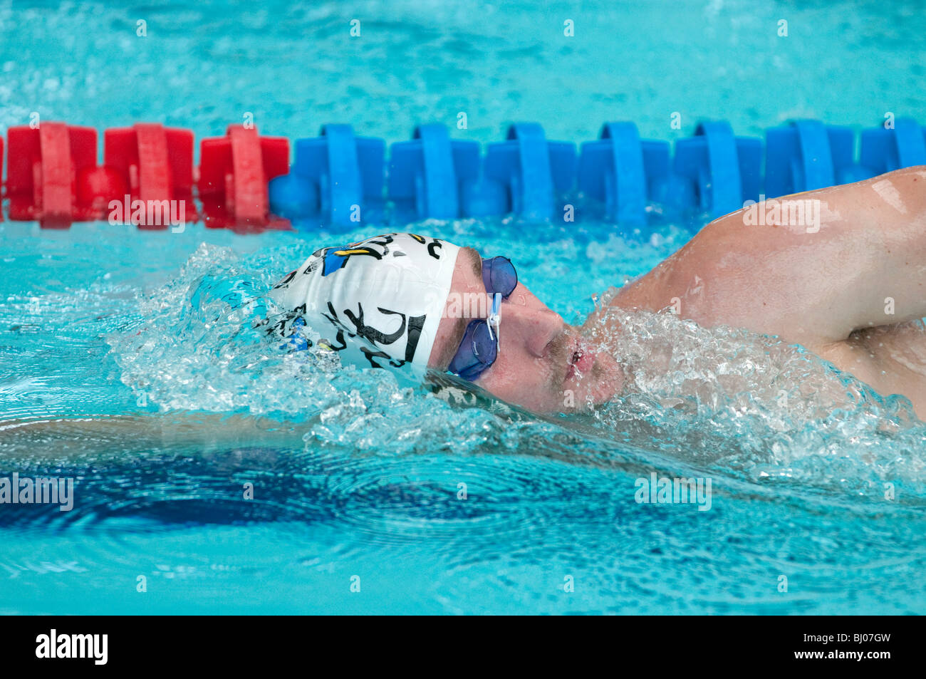 Male swimmer with white swimming cap in competition Stock Photo - Alamy
