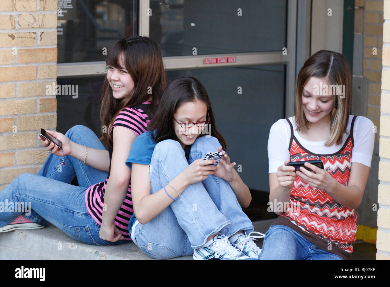 Teen girls texting and having fun Stock Photo - Alamy