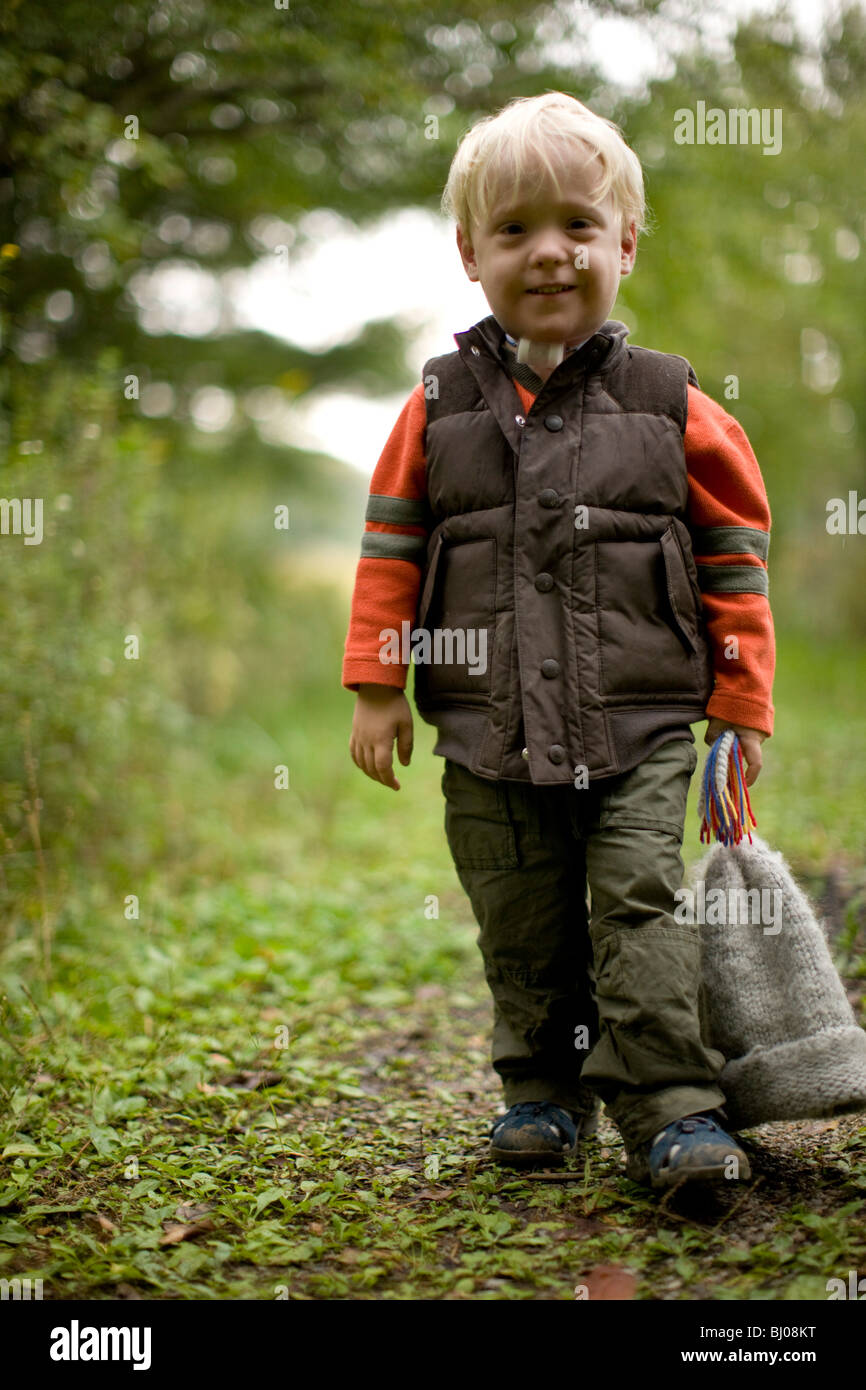 Young boy standing outside holding his winter hat Stock Photo - Alamy