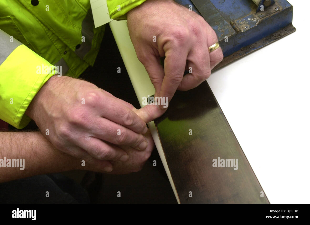 Police officer takes a mans right thumb and places it on an ink board ...