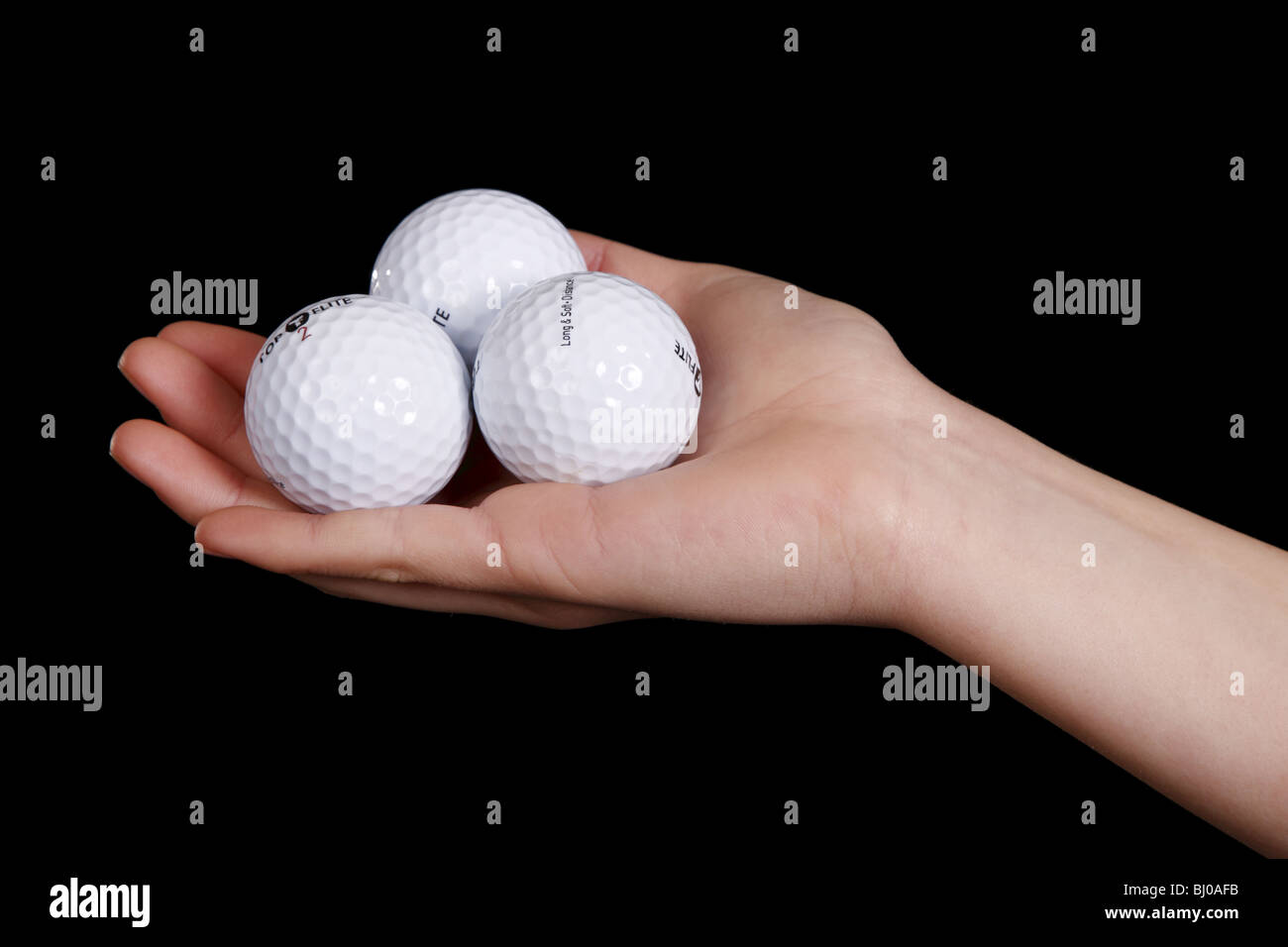A hand holding three golf balls Stock Photo - Alamy