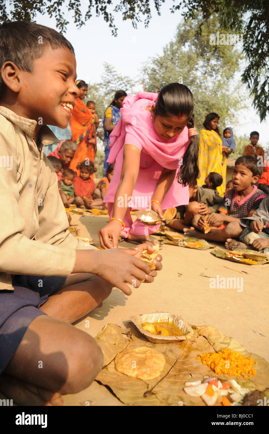 young boy enjoys a celebratory feast with his friends sharing his food ...