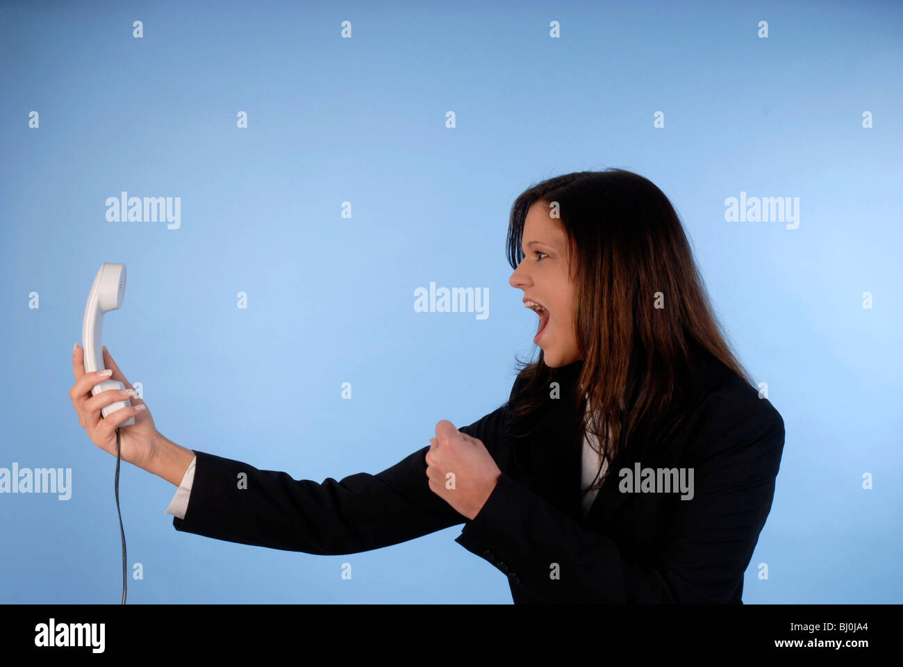 Young woman screaming into the phone Stock Photo - Alamy