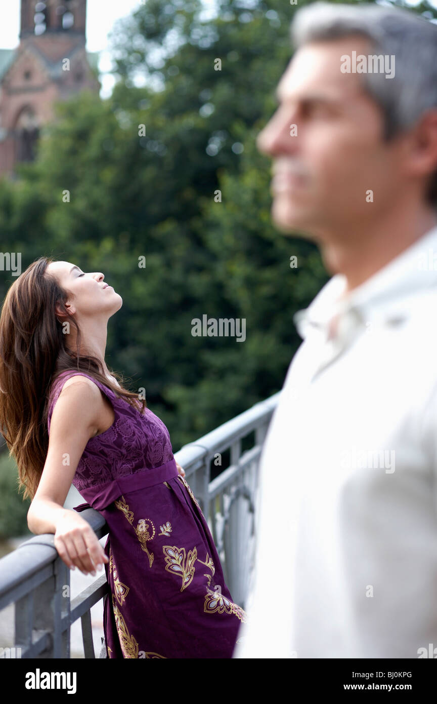 couple in city woman leaning against railing Stock Photo - Alamy