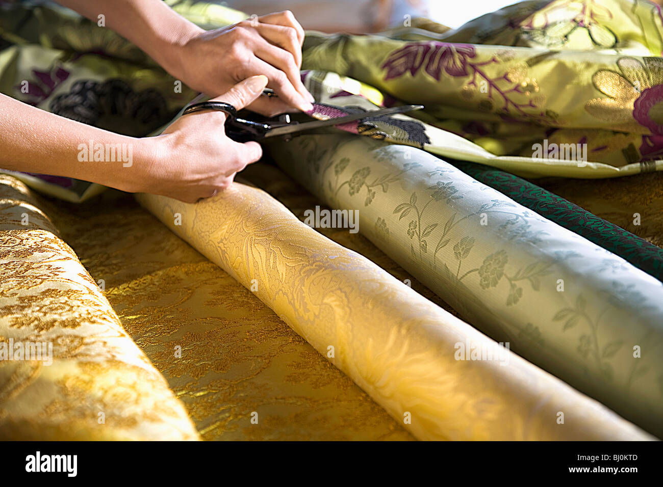 detail of woman cutting roll of cloth with scissors Stock Photo - Alamy