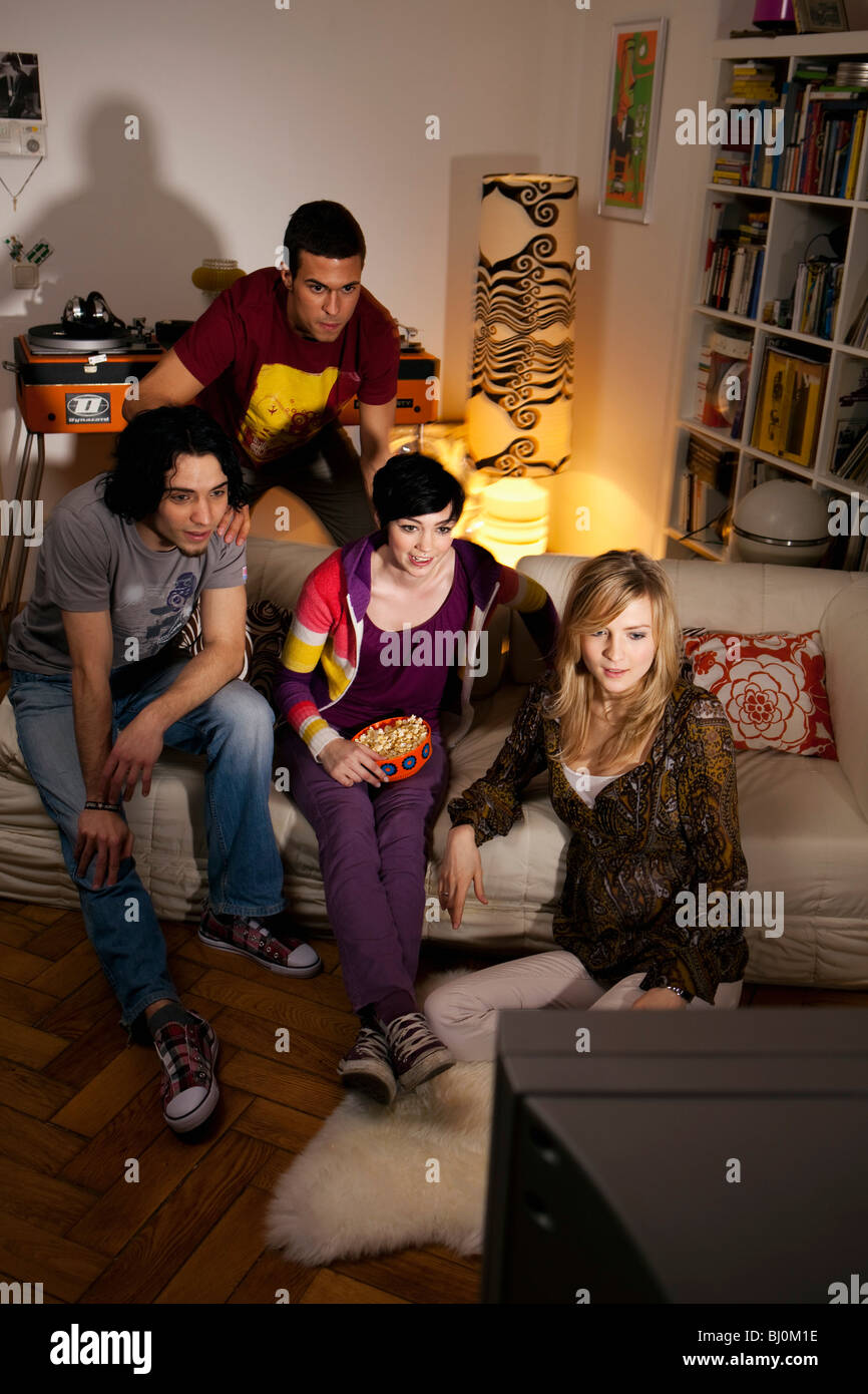 group of four friends watching television Stock Photo - Alamy