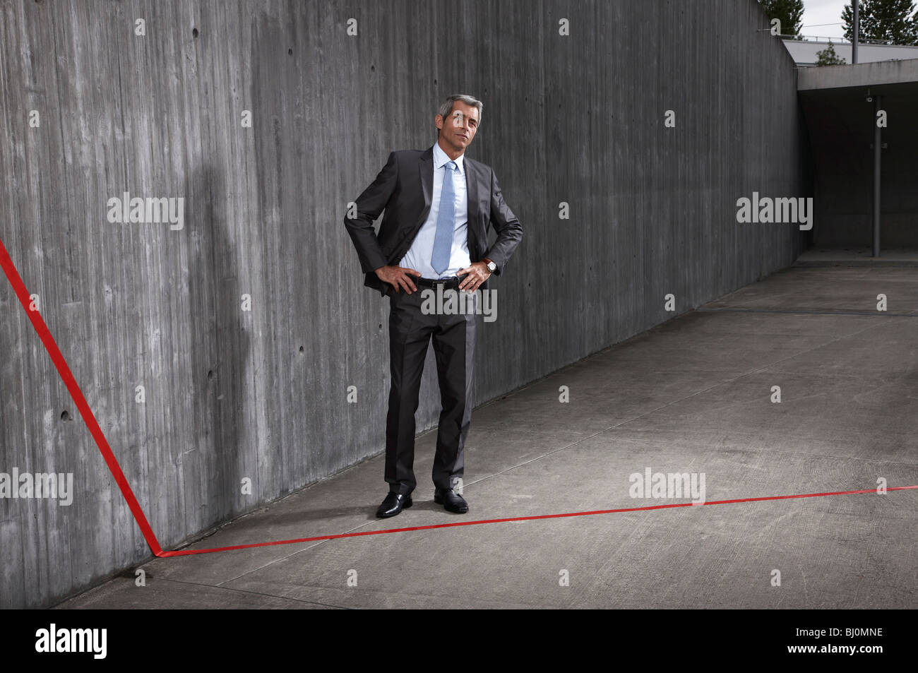 businessman standing behind red line Stock Photo - Alamy