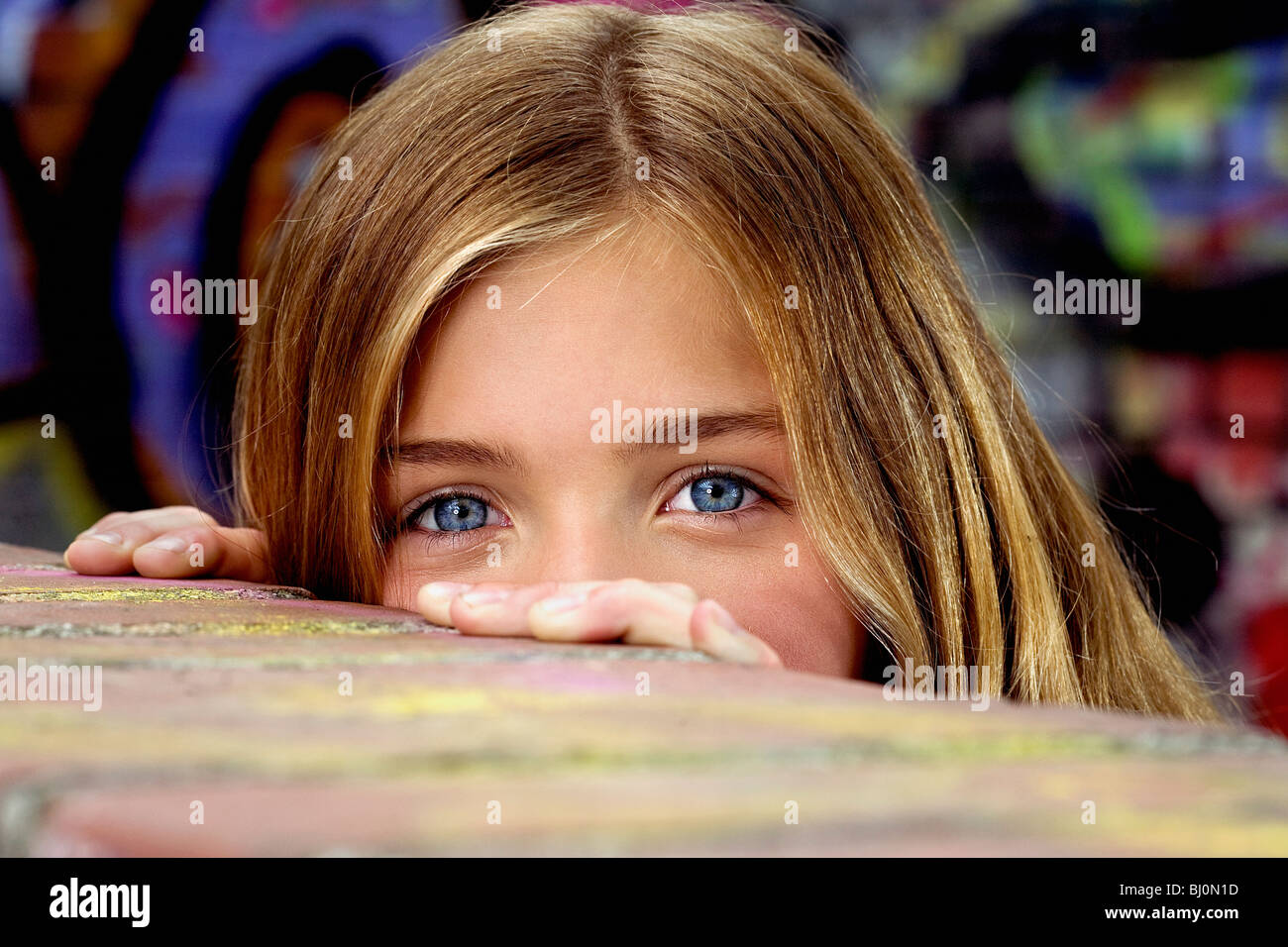 young girl peeking over wall Stock Photo - Alamy