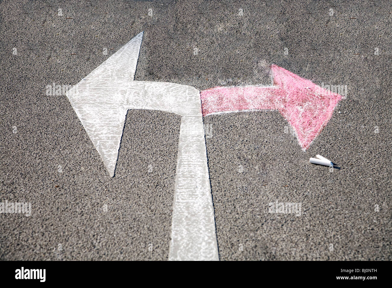 red arrow drawn on road in opposite direction of road sign Stock Photo ...