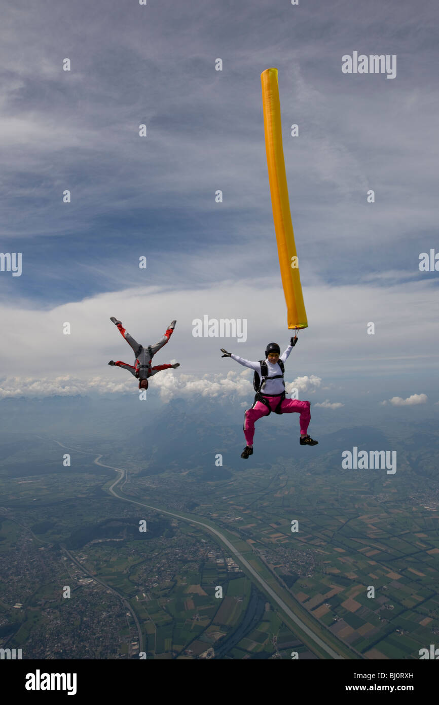 Skydivers with orange air tube is flying high in the sky The other ...