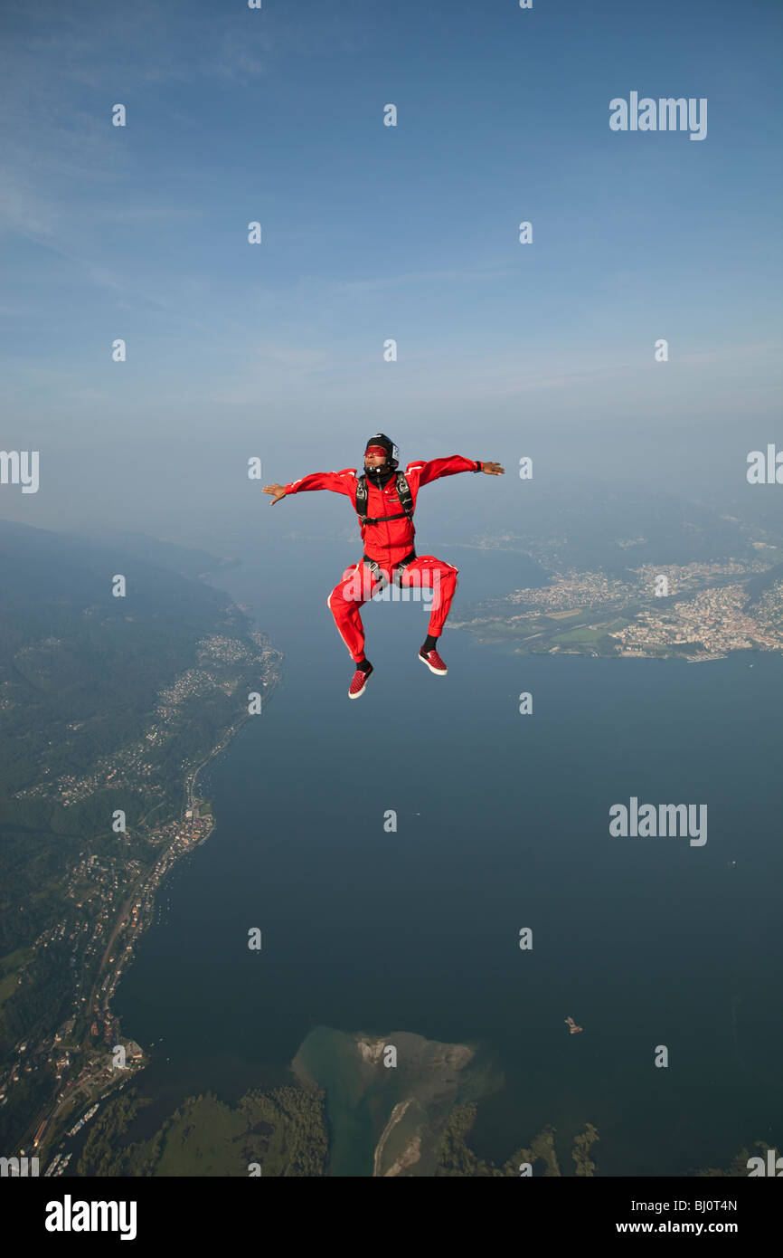 Skydiver is flying head up within the sit fly position over a ...