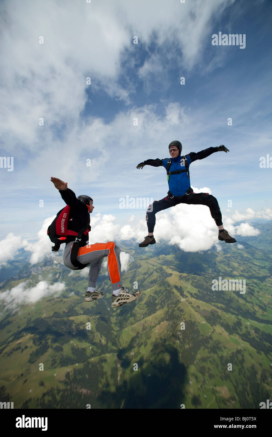 Skydiver are flying head up within a team in the sit fly position over ...