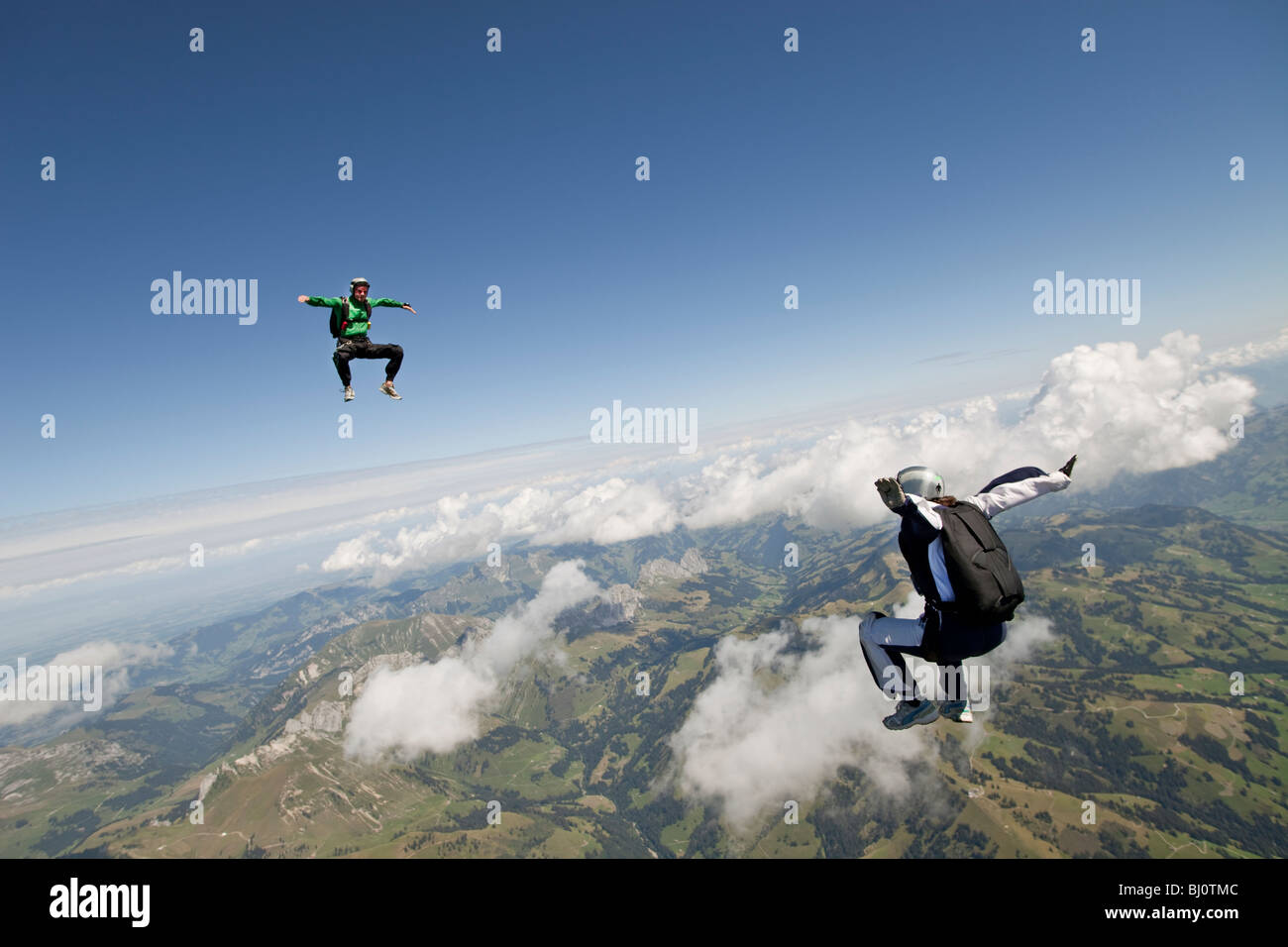 Skydivers are flying head up within the sit fly position over a ...