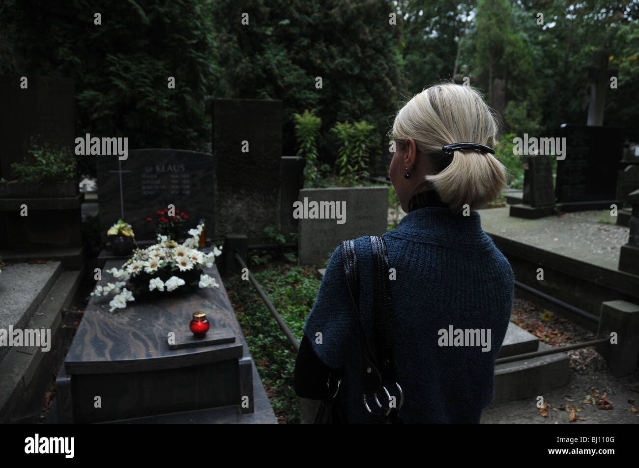 Woman visiting grave of her relatives Stock Photo - Alamy