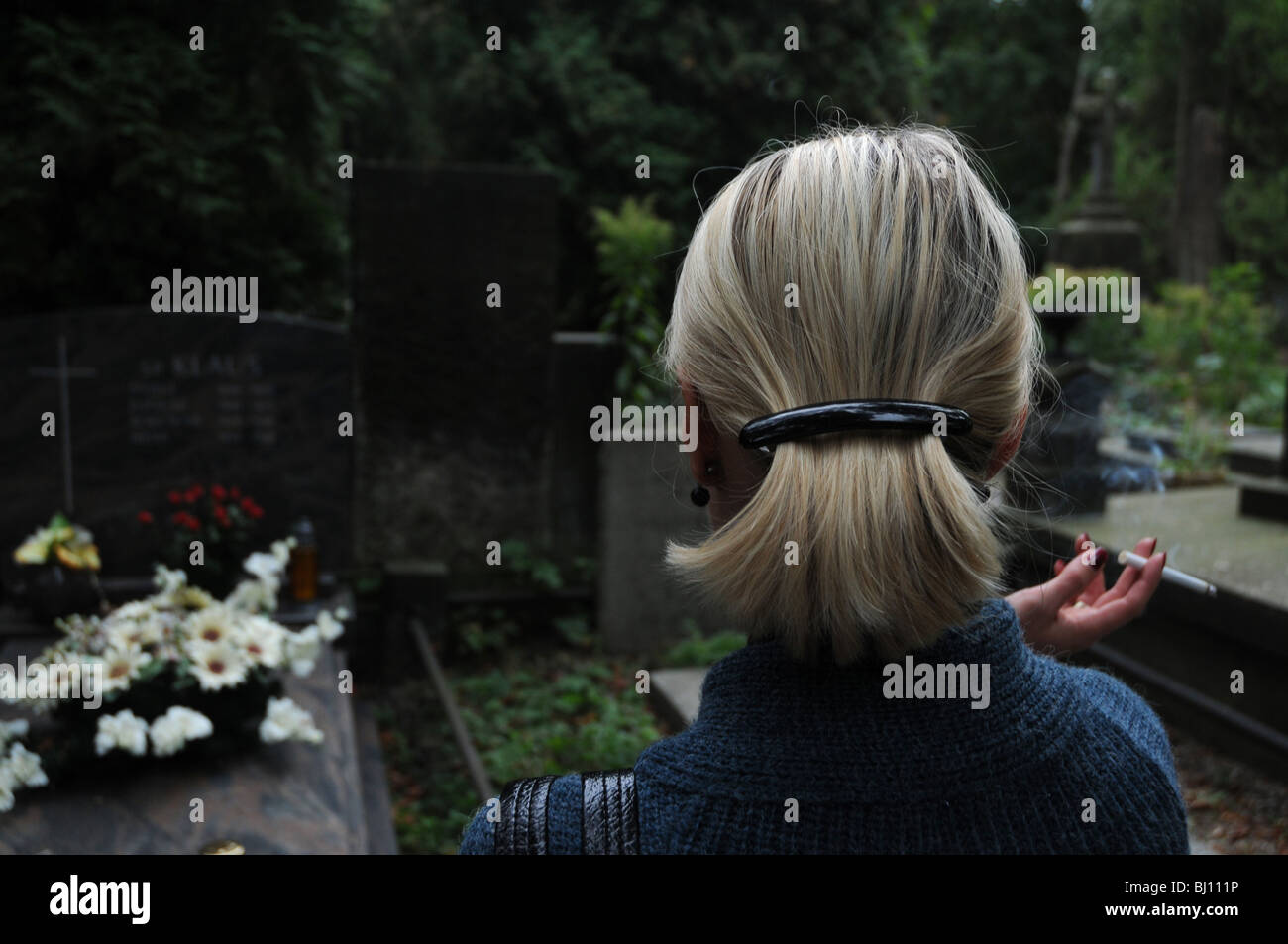 Woman visiting grave of her relatives Stock Photo - Alamy