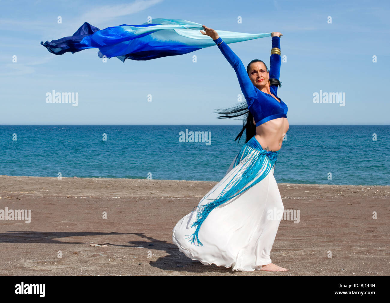 Belly Dancer on a beach with veil blowing in the wind Stock Photo - Alamy