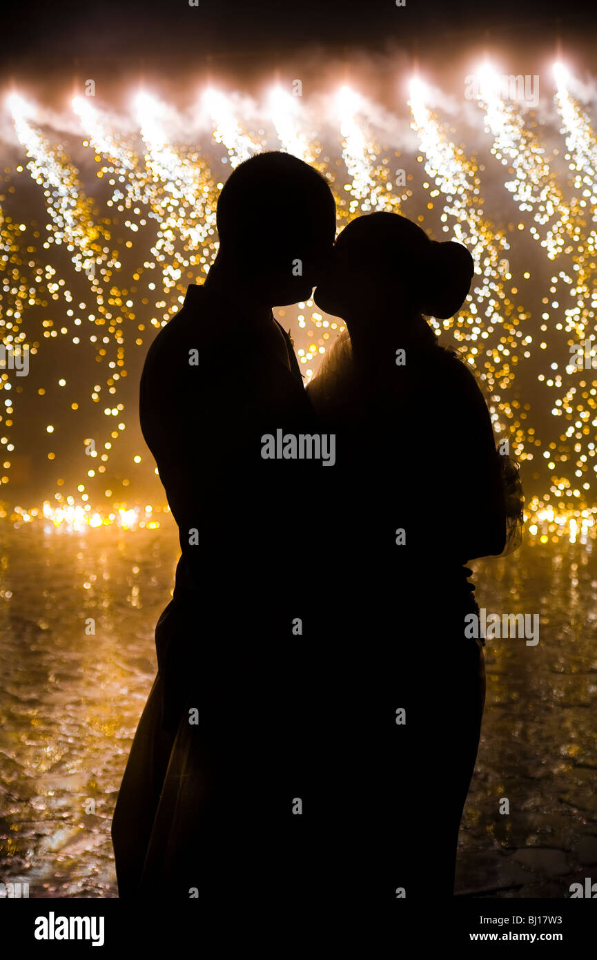 Silhouette of bride and groom kissing in front of fireworks Stock Photo ...