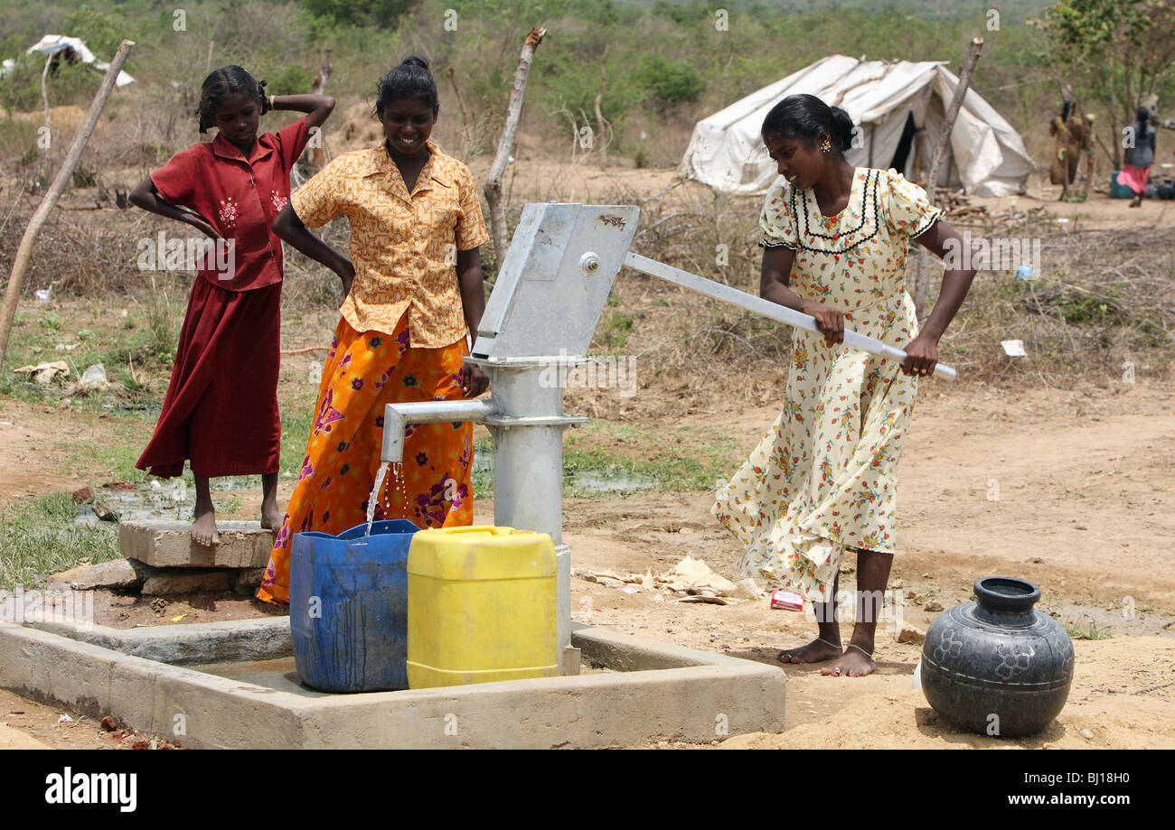 Women doing laundry at a water pump in a shelter for Internally ...