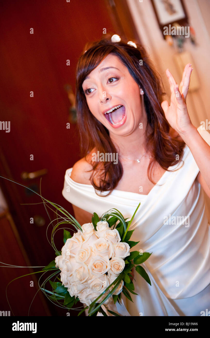 Excited bride holding flower bouquet at wedding Stock Photo - Alamy