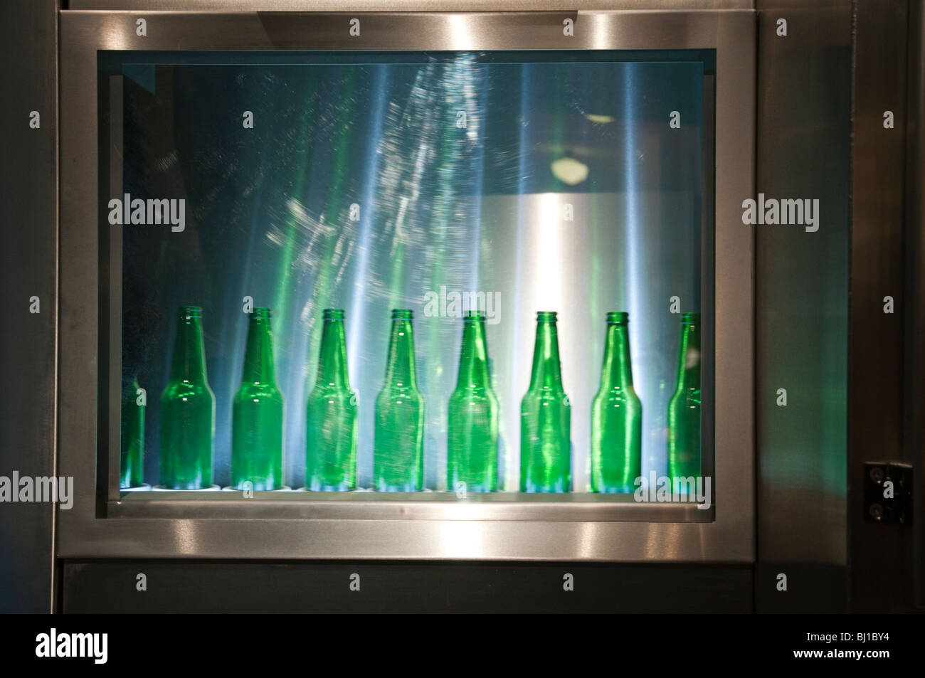 Glass bottles being processed and labelled during the beer production ...