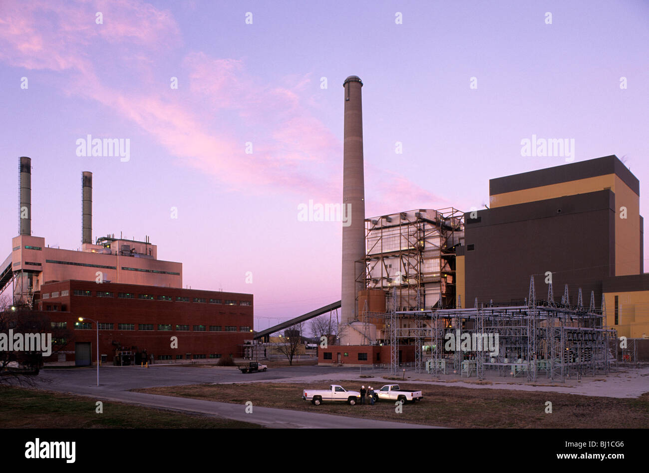 coal fired power plant with two utility workers standing around pick up ...