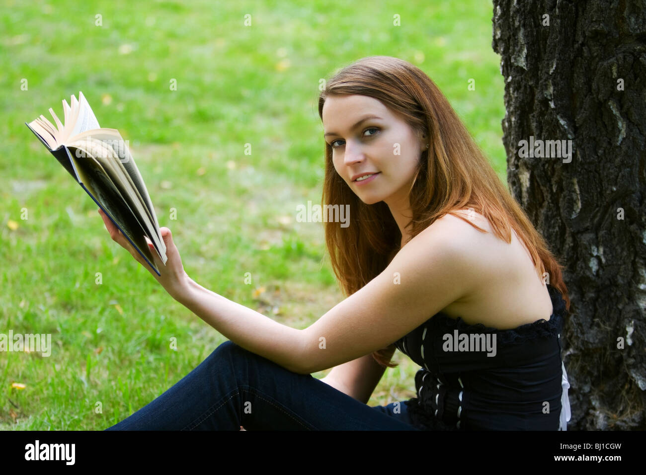 Young woman reading a book on nature Stock Photo - Alamy