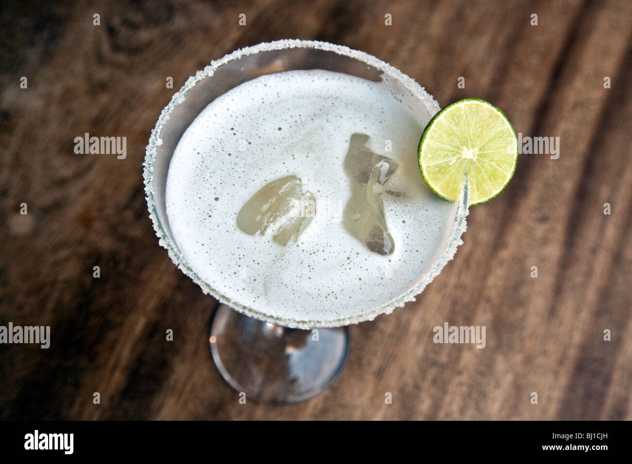 traditional icy Mexican margarita drink with lime slice & salt crusted ...