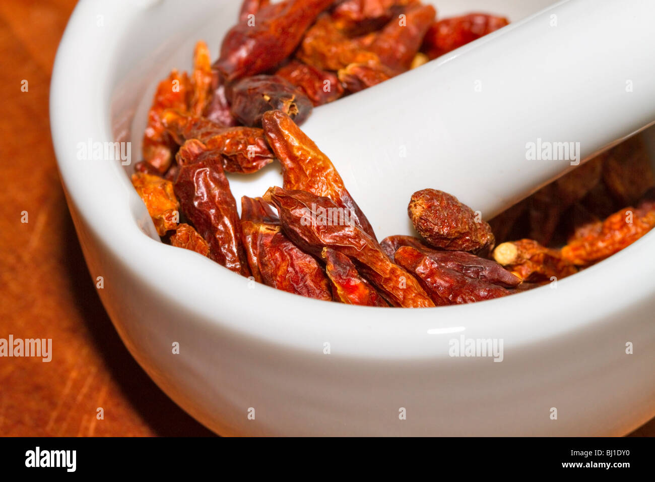 Dried whole cayenne peppers in a mortar and pestle Stock Photo - Alamy