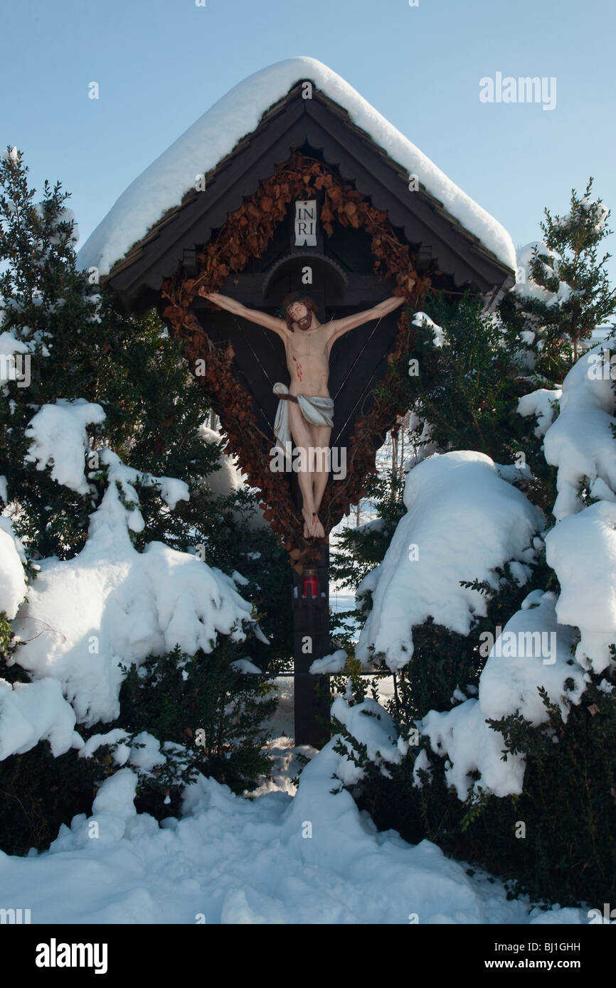 Jesus on the cross surrounded by snow-covered bushes Stock Photo - Alamy
