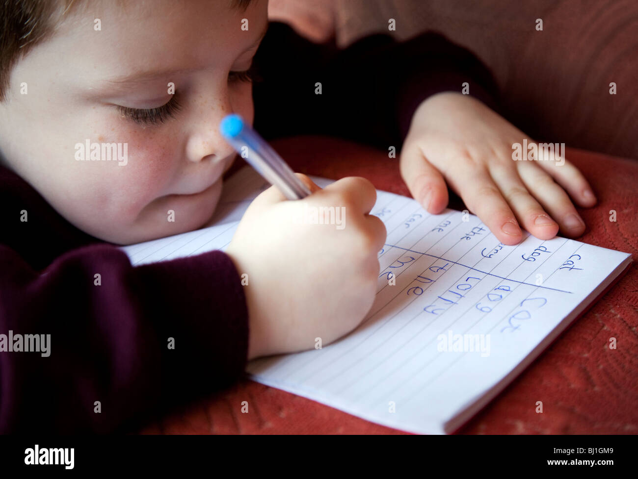 A young boy practices his writing skills Stock Photo - Alamy