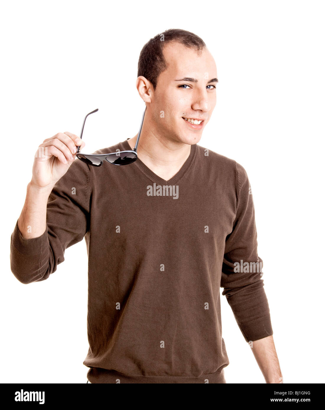 Portrait of a confident young man taking off the sunglasses, isolated ...