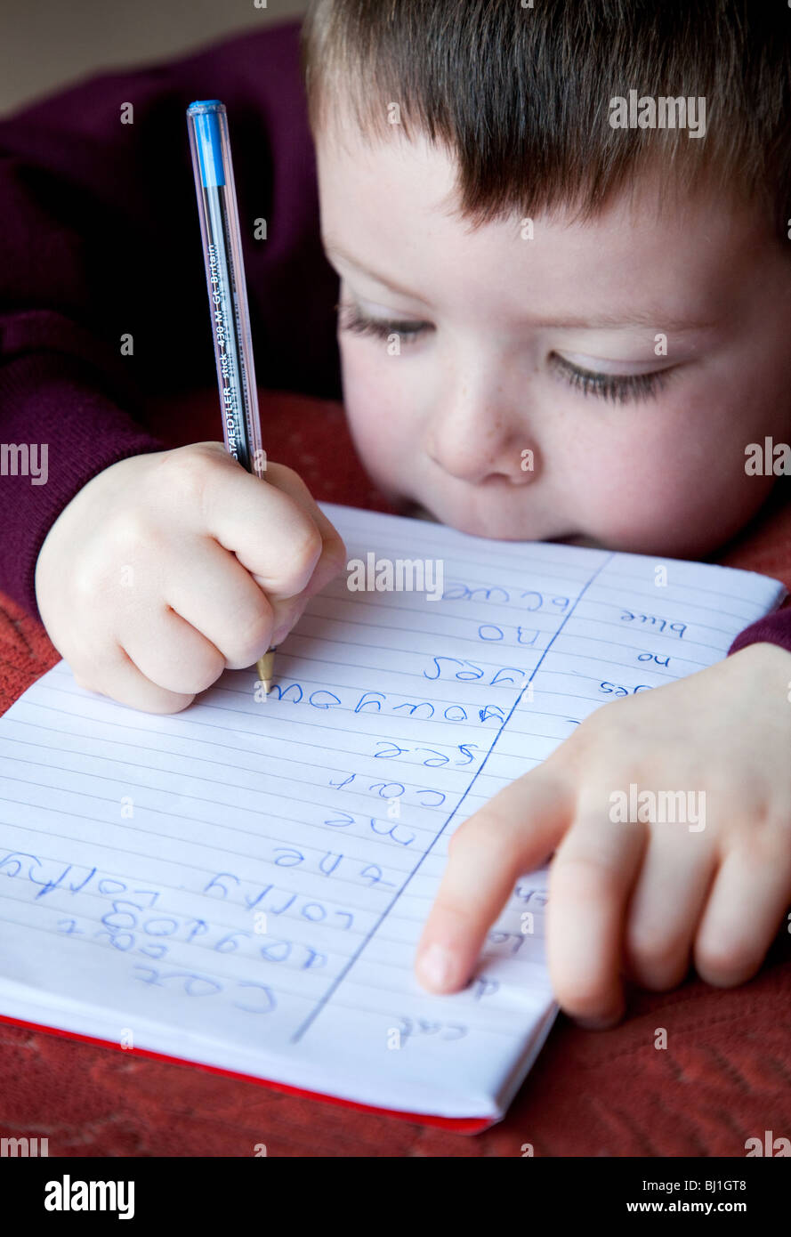 A young boy practices his writing skills Stock Photo - Alamy