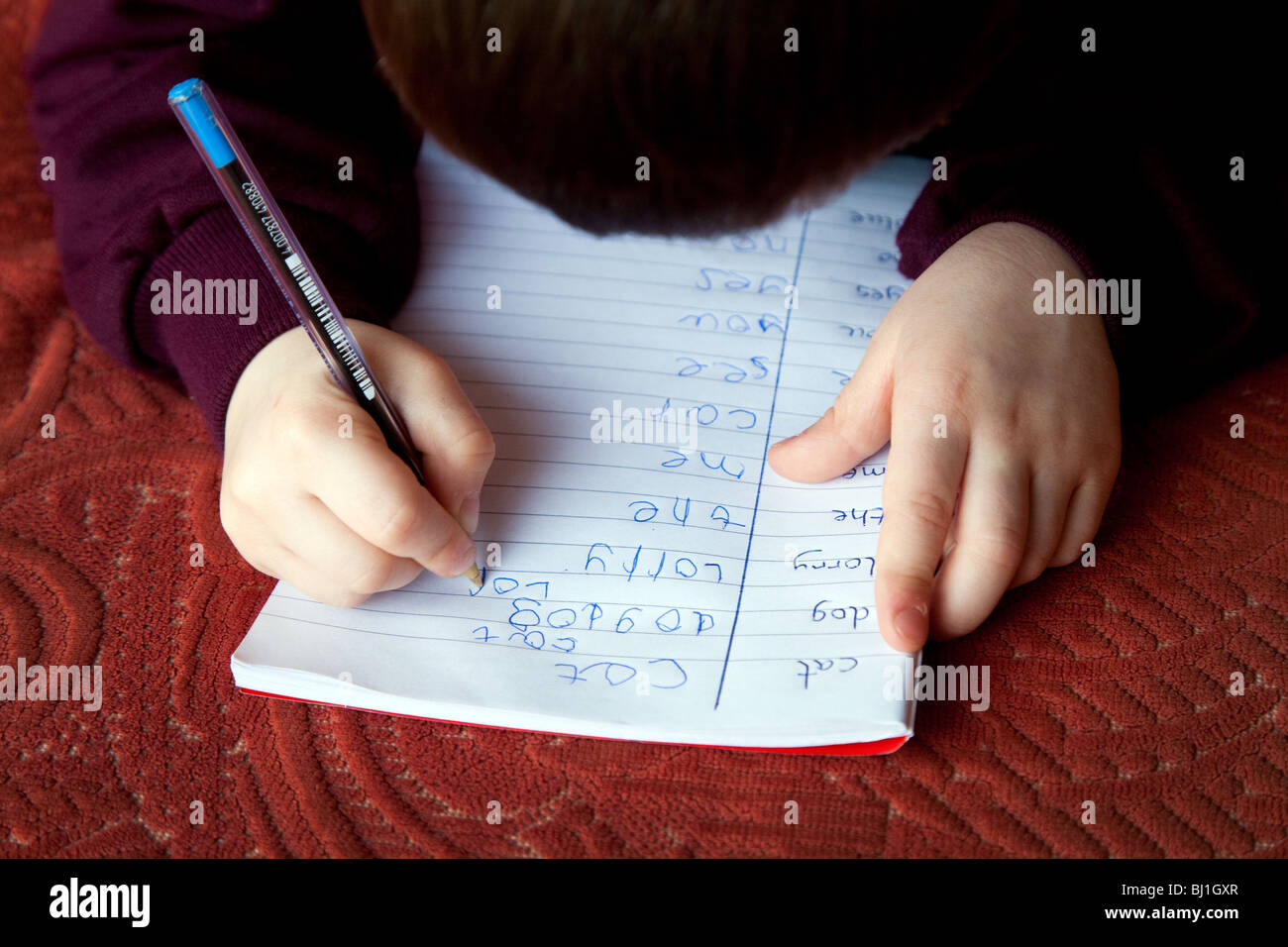 A young boy practices his writing skills Stock Photo - Alamy