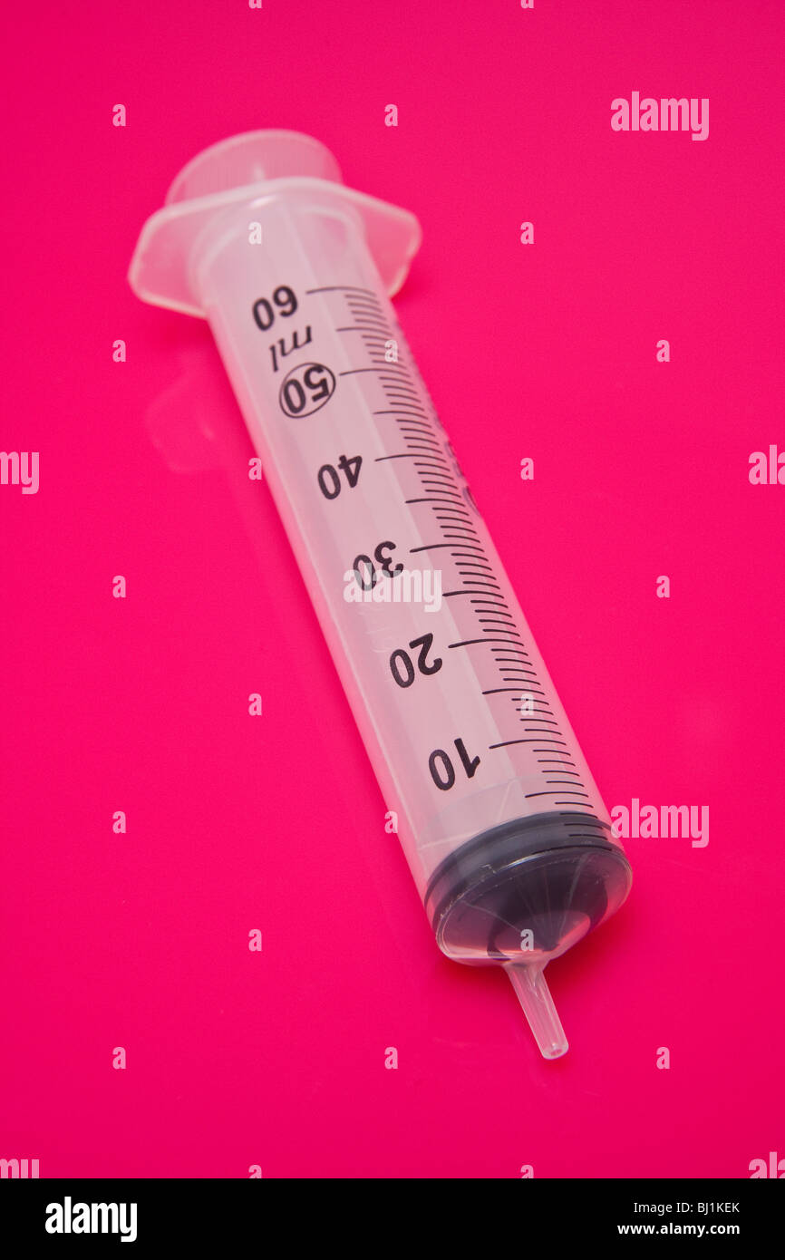syringe on a bright pink studio background Stock Photo - Alamy