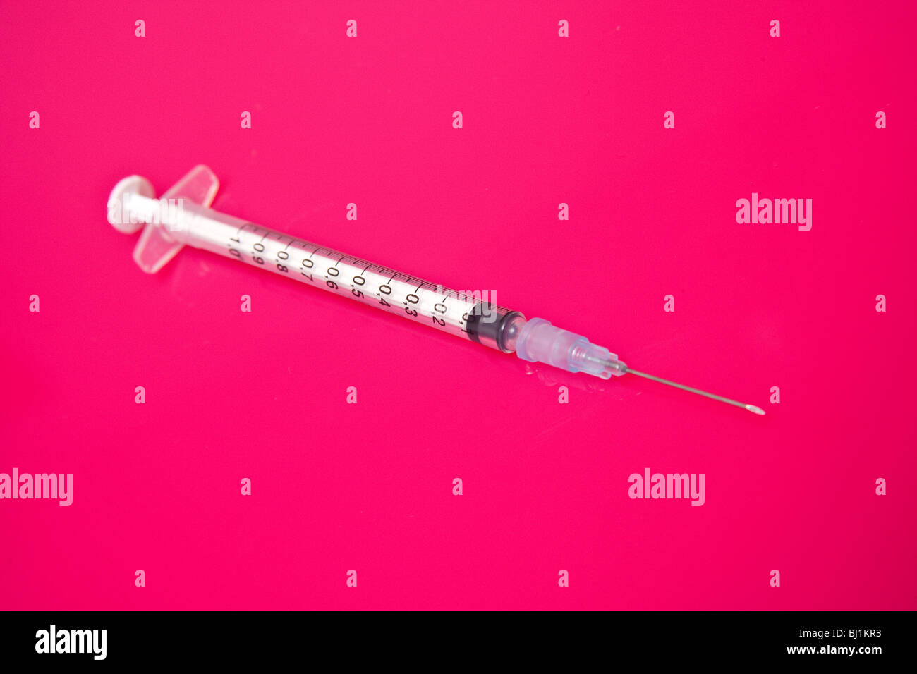 Needle and syringe on a bright pink studio background Stock Photo - Alamy