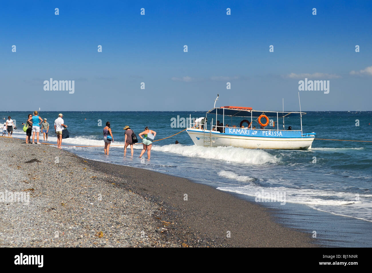 A shuttle boat, connecting Kamari and Perissa, is picking up passengers ...