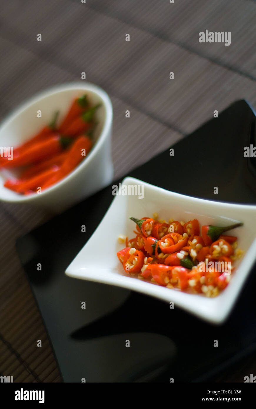 An Asian style serving bowl with chopped red chillis and a bowl of ...