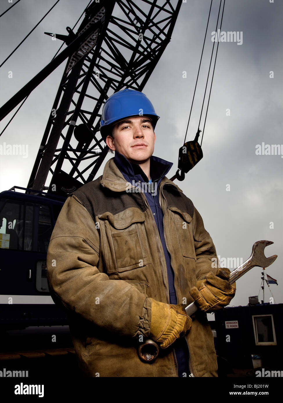 Crane driver wearing hard hat posing in front of his crane. Amsterdam ...