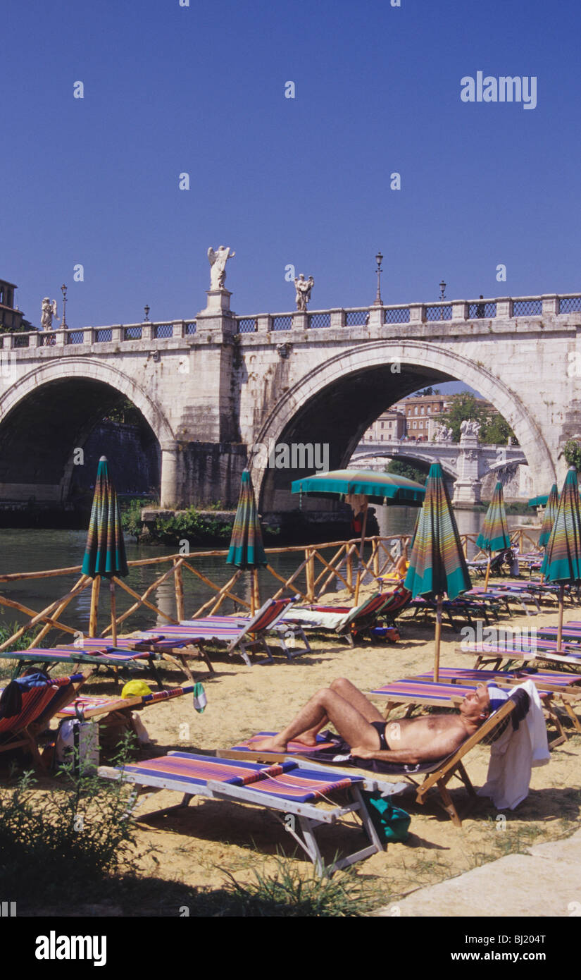 People sunbaking on deckchairs at artificial beach by the river Tevere ...