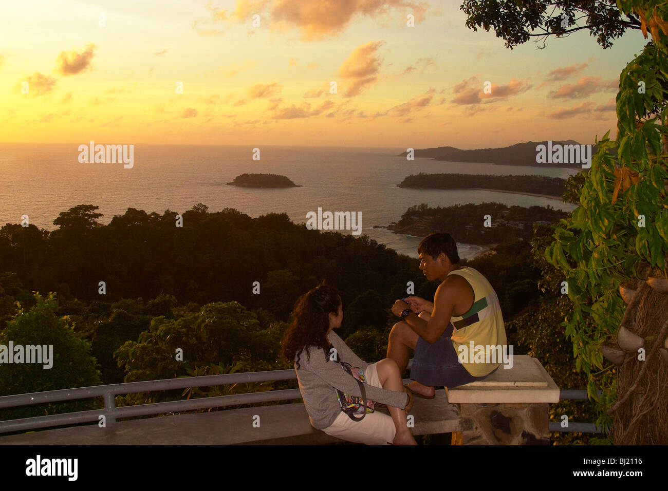 Tourists taking in the view at sunset of the beach resorts of Karon ...