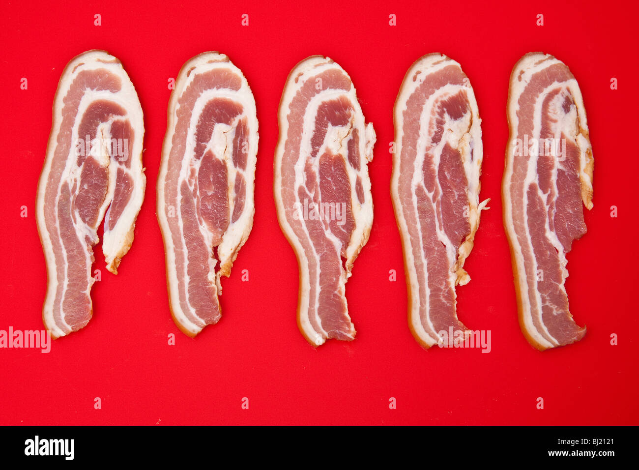 Steaky bacon rashers isolated on a red studio background Stock Photo ...