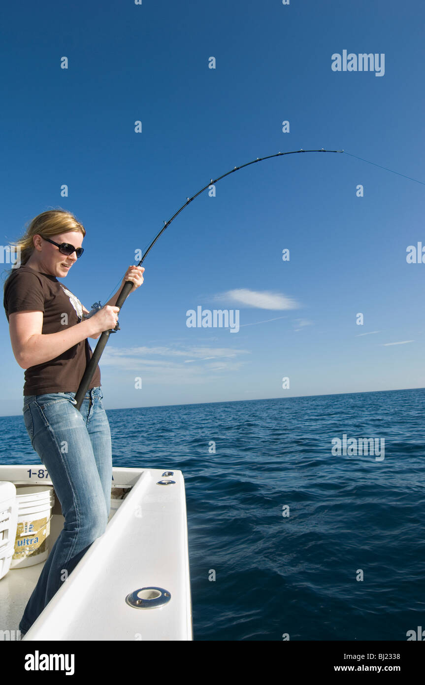 Woman fishing on a boat Stock Photo - Alamy
