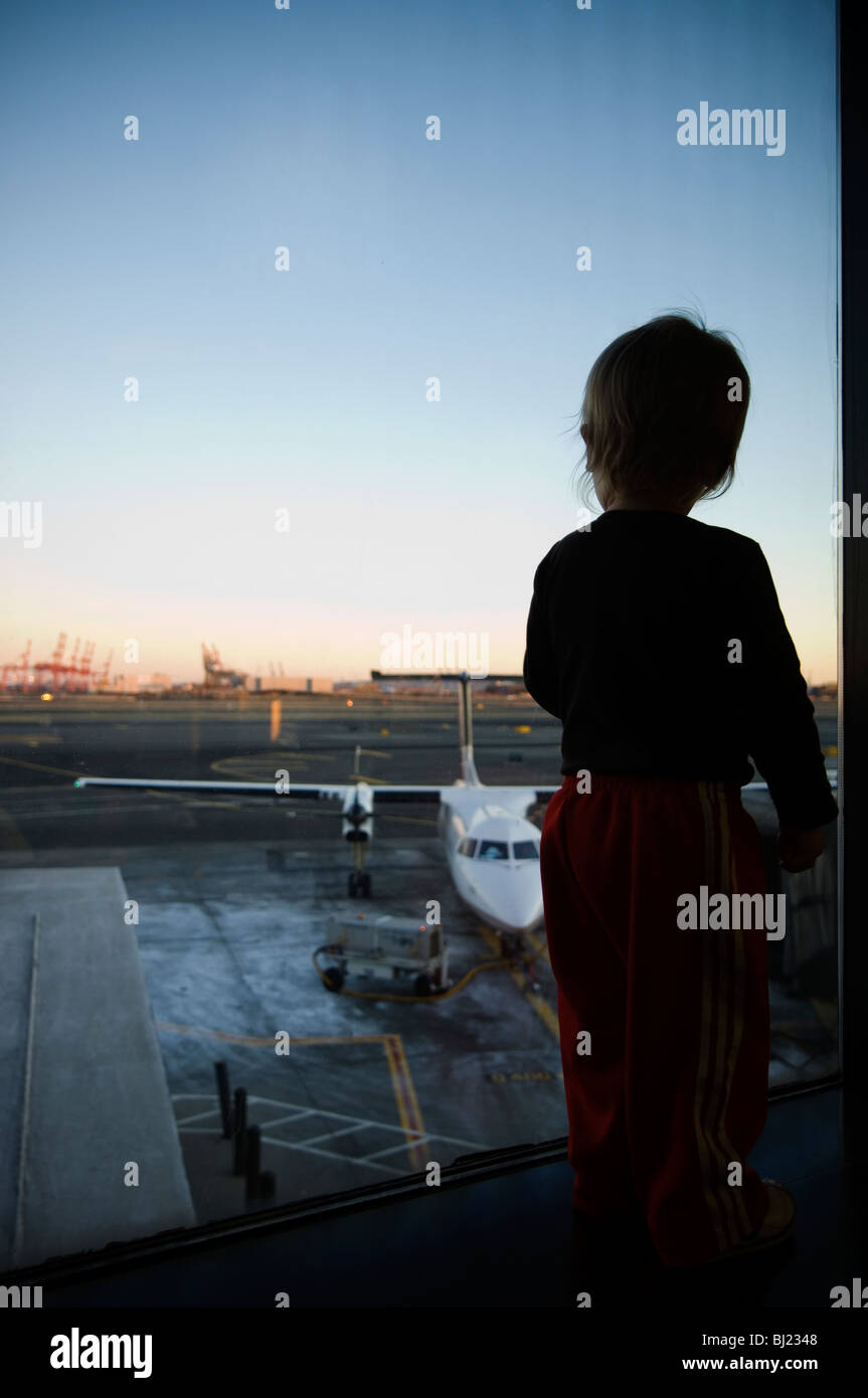 A boy watching a airfield through a window Stock Photo - Alamy