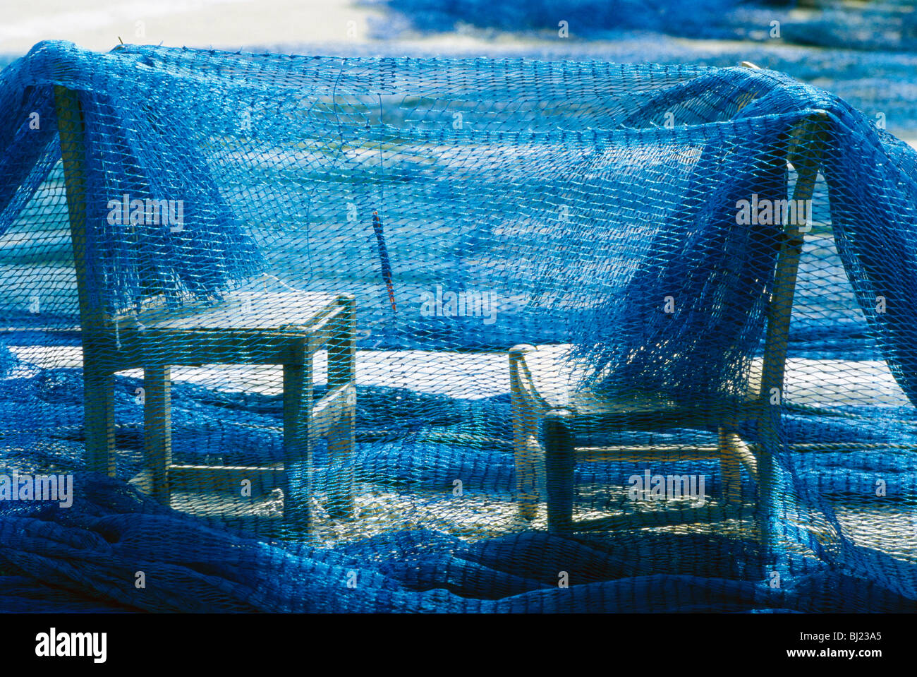 Fishing-net hanging on two chairs, Spain Stock Photo - Alamy