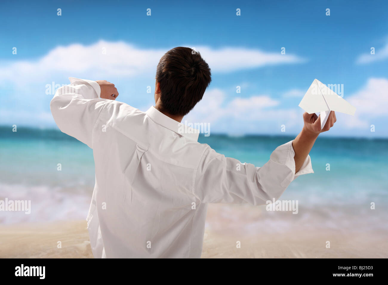 Man playing paper airplane on beach Stock Photo - Alamy