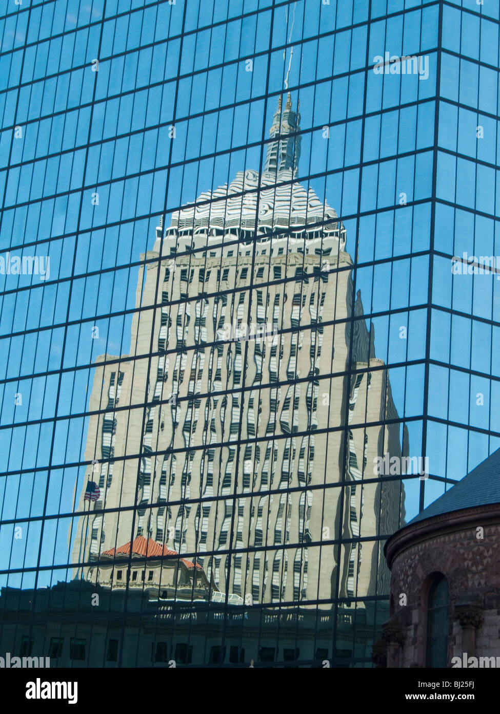 The Berkeley Building reflected in the glass of the John Hancock Tower in Boston Massachusetts ...