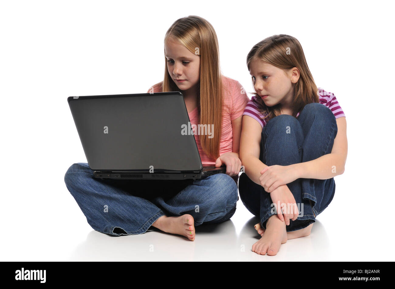 Two girls with a laptop isolated on a white background Stock Photo - Alamy