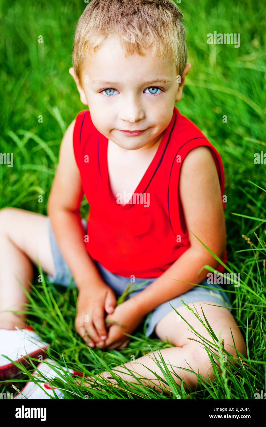Portrait of cute serene kid on fresh green grass Stock Photo - Alamy