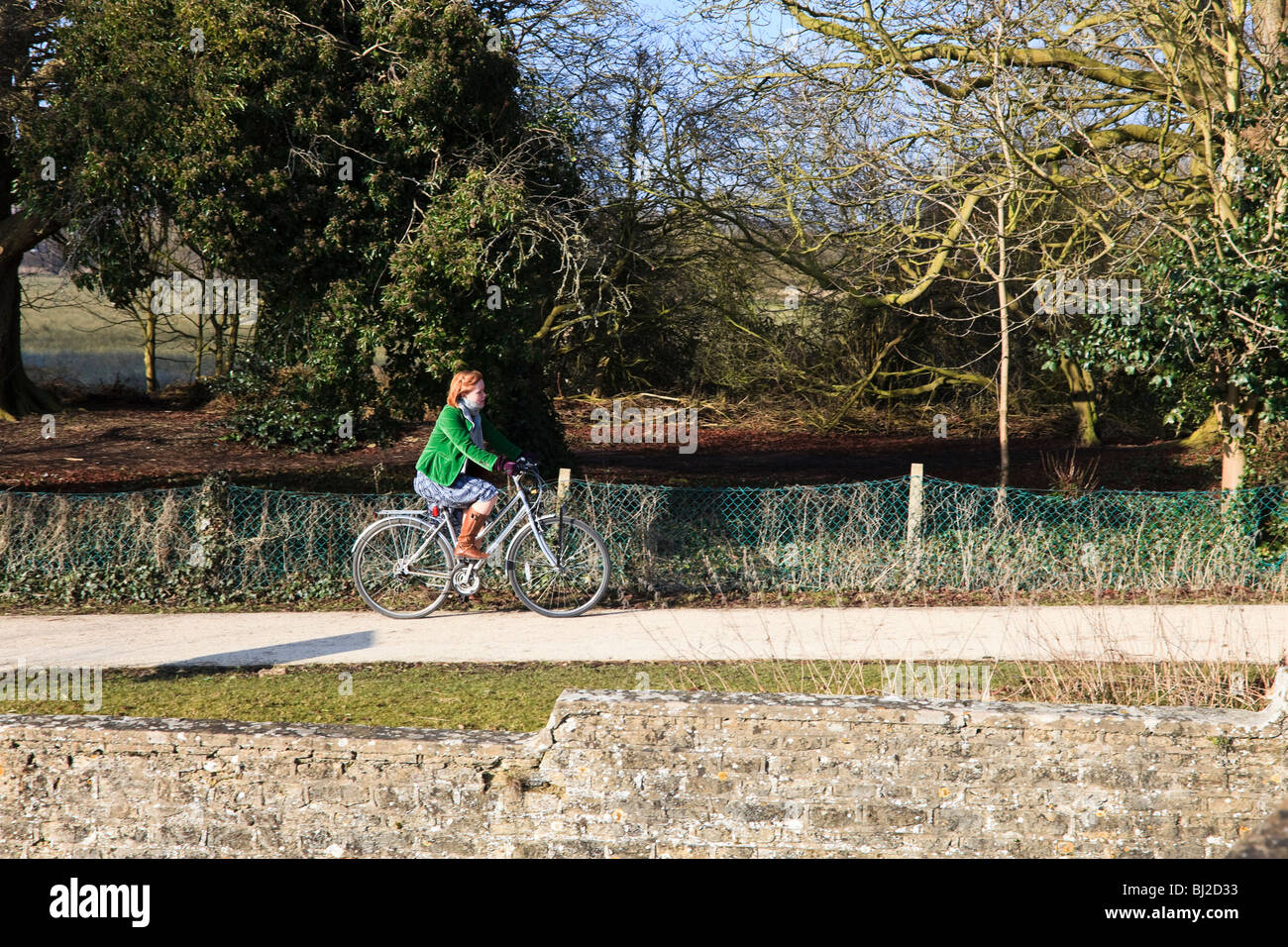 A pretty girl rides her bike along the Thames path at Iffley, Oxford ...